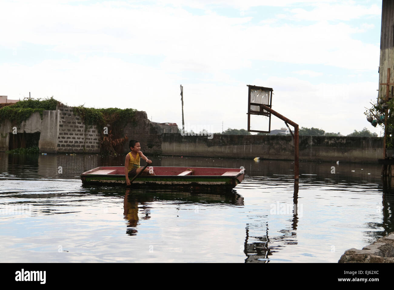 Manila, Philippines. 22nd Mar, 2015. A young boy paddles his way ...