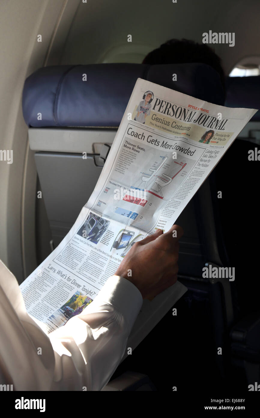 Man reads newspaper on airplane in airplane seat Stock Photo - Alamy