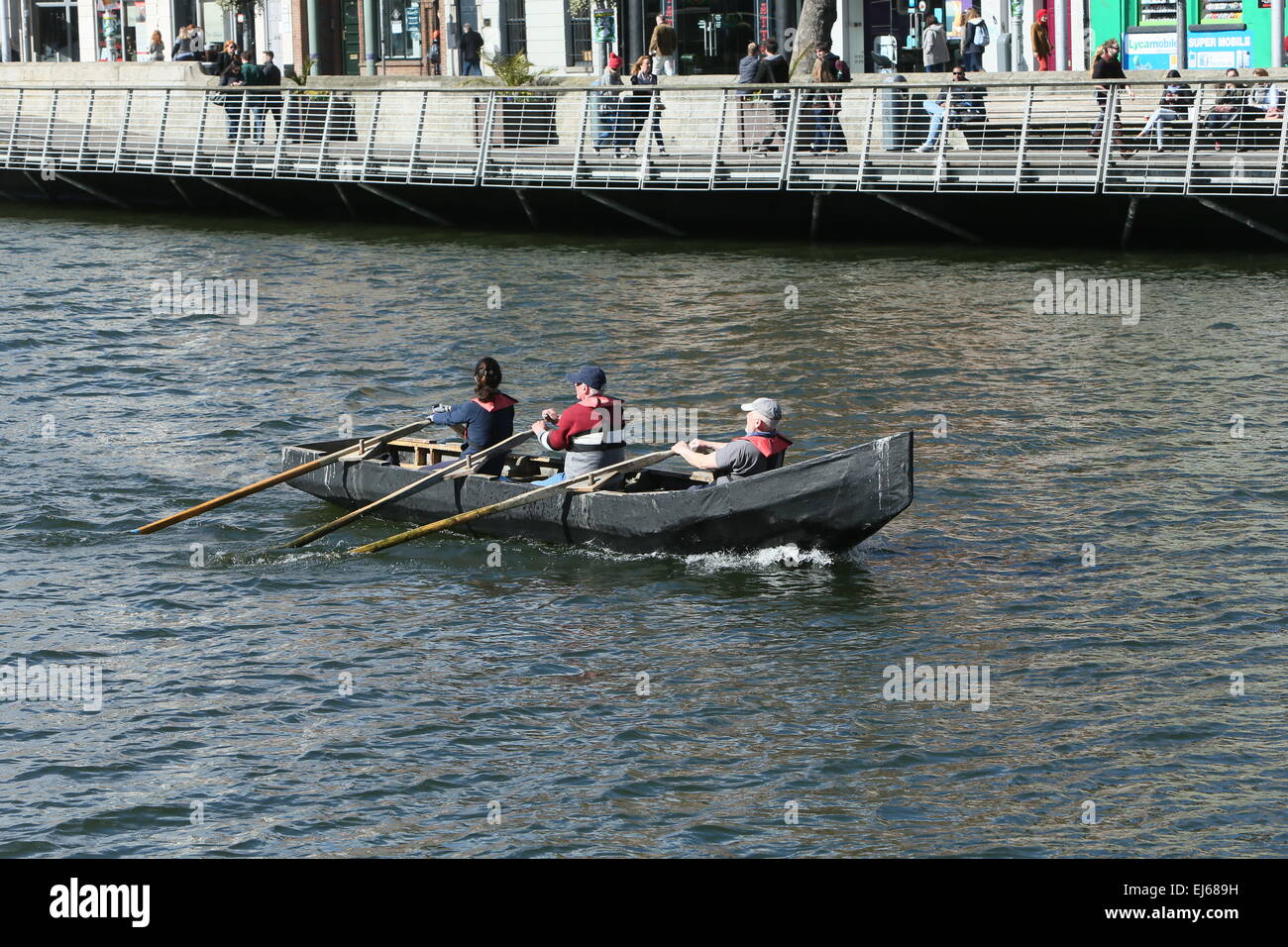 People row in a currach on the River Liffey in Dublin city centre on ...