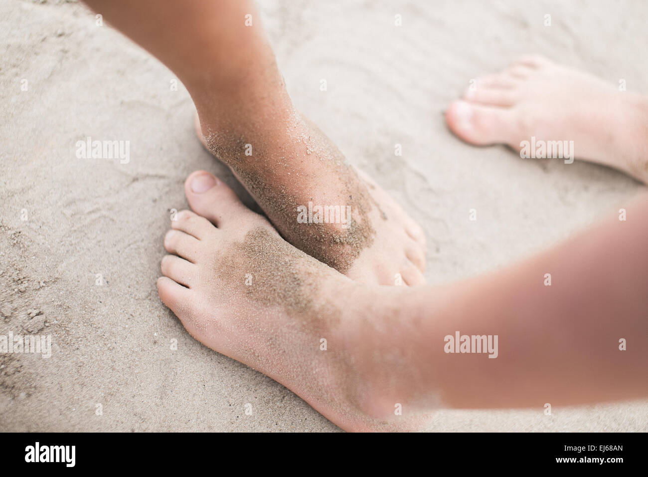 Toddler feet on sand at the beach. Children playing barefoot. Having ...