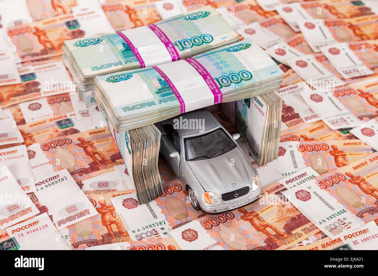 Toy car in the garage of the bundles of money Stock Photo - Alamy