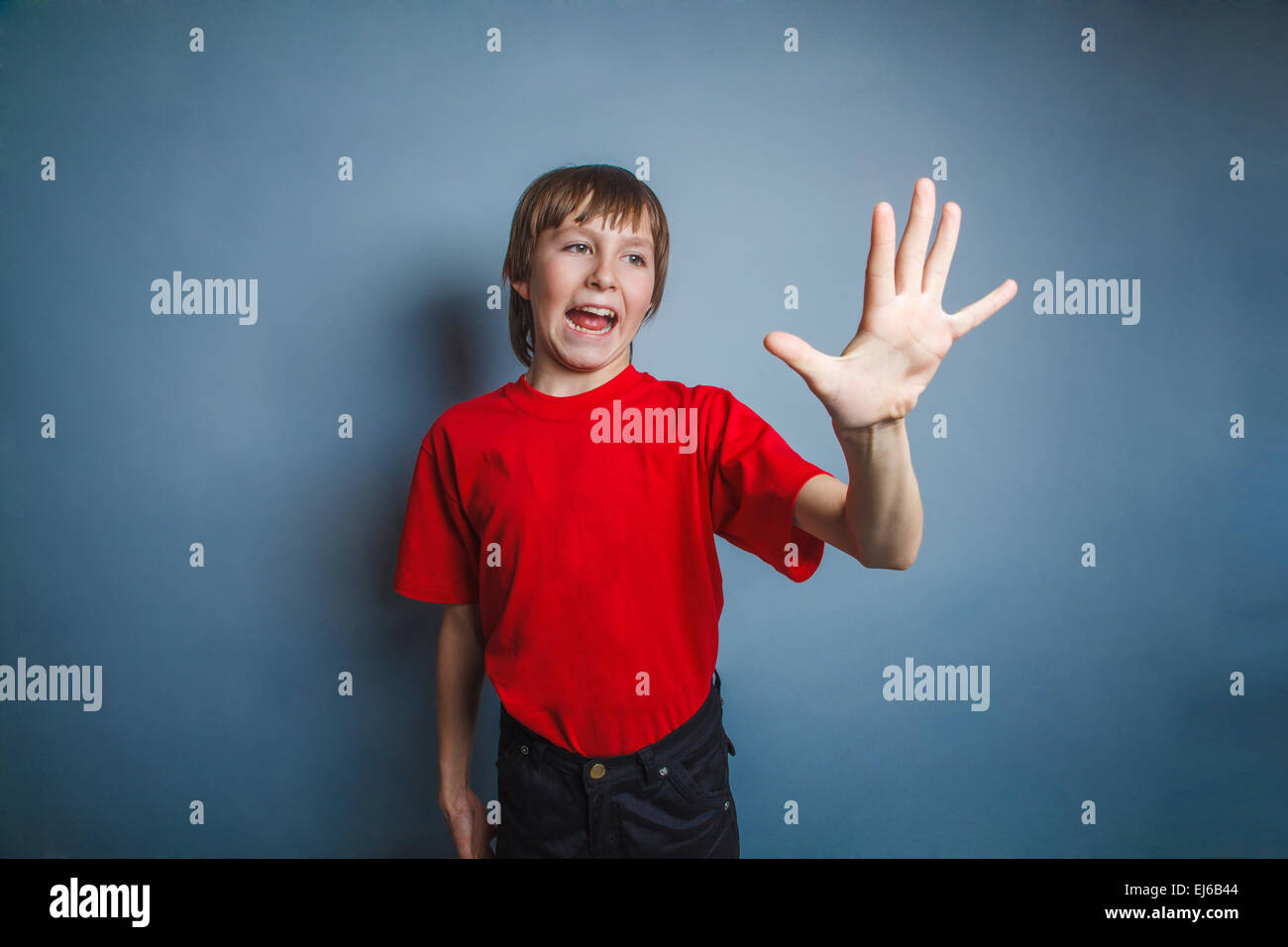 Boy, teenager, twelve years old, in a red shirt, showing hand Stock ...