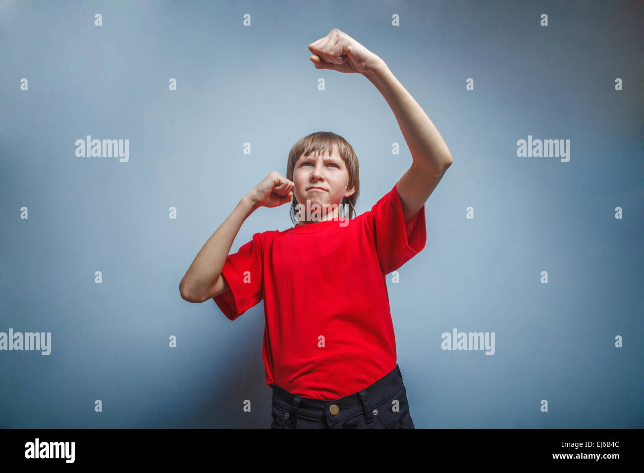Boy, teenager, twelve years red in shirt, showing his fists Stock Photo ...