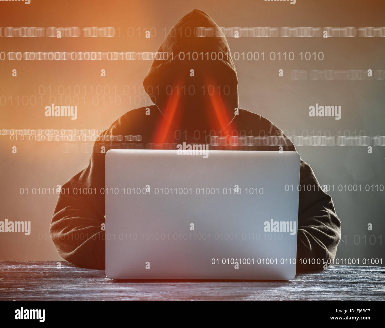 A hacker with a hood with laptop. Online network danger Stock Photo - Alamy