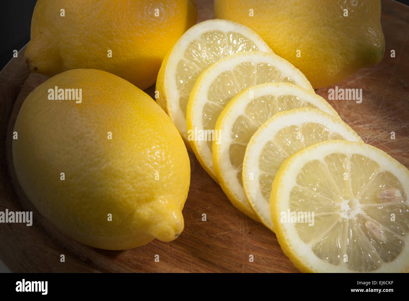 cut lemons at wooden board Stock Photo - Alamy