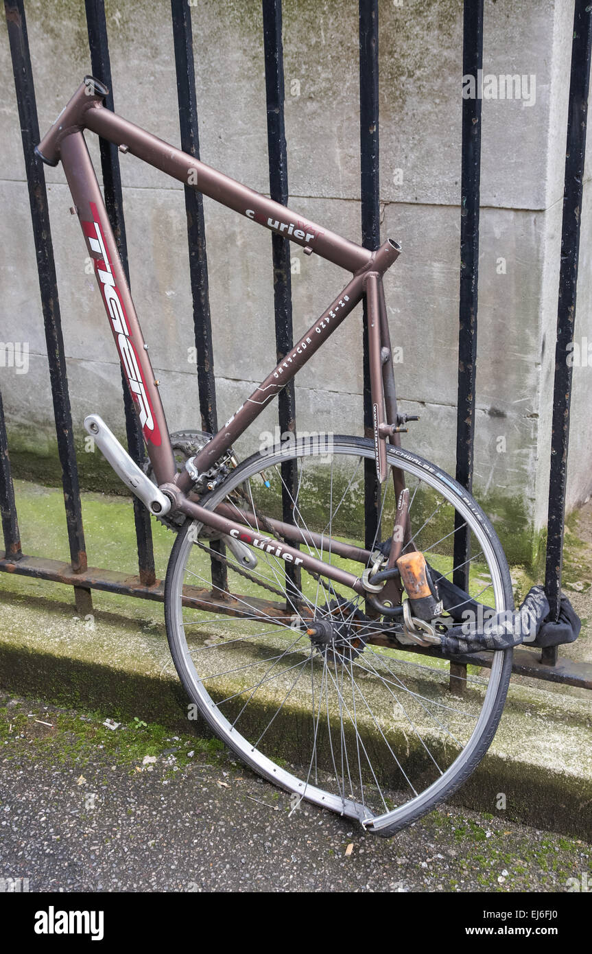 Damaged bicycle locked to fence, London England United Kingdom UK Stock ...