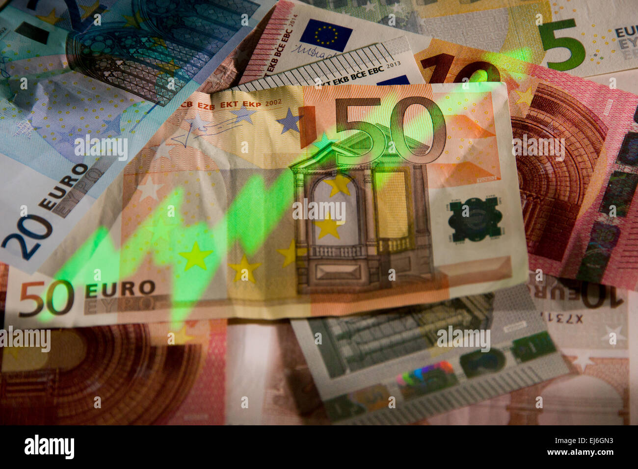 Upward trending 'stock market graph' projected onto a pile of Euro ... Upward trending 'stock market graph' projected onto a pile of Euro ...