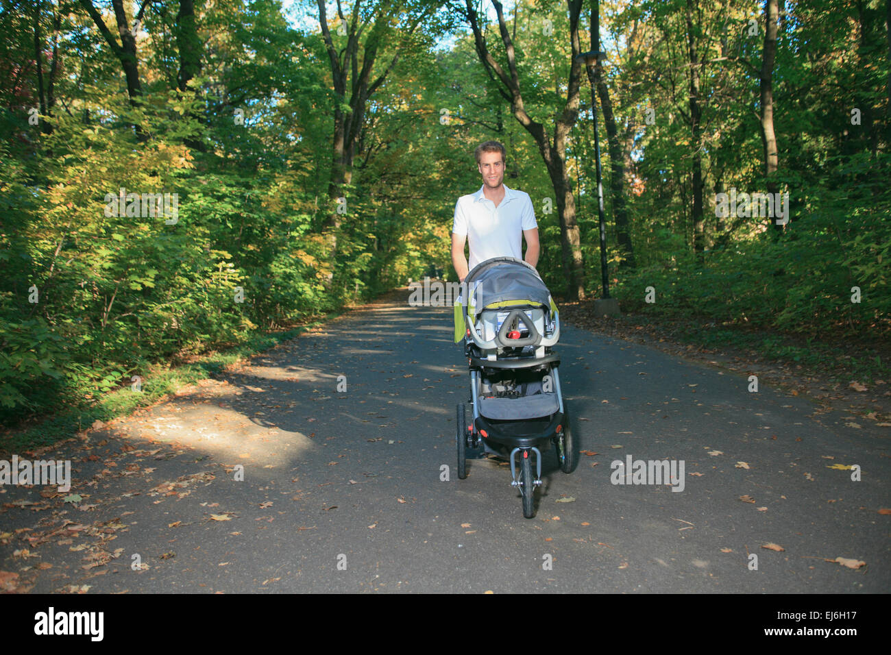 30 years old man with a stroller walking in the park Stock Photo - Alamy