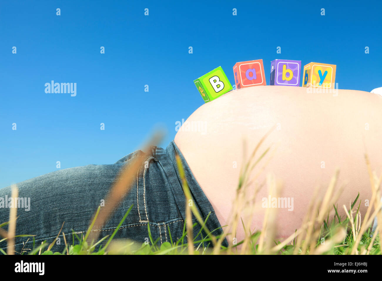 Alphabet blocks spelling BABY on a pregnant belly Stock Photo - Alamy
