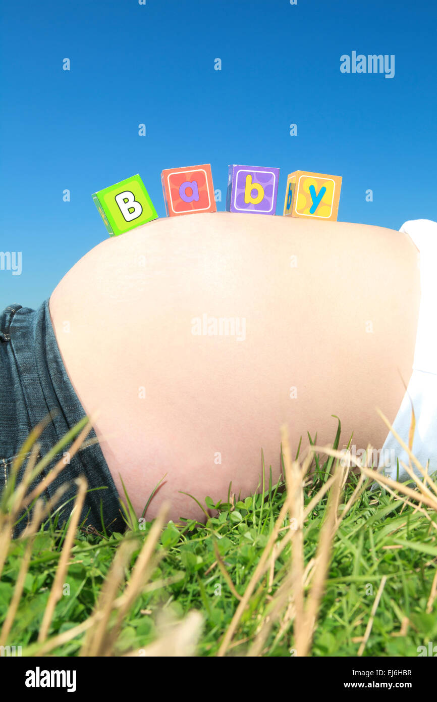 Alphabet blocks spelling BABY on a pregnant belly Stock Photo - Alamy