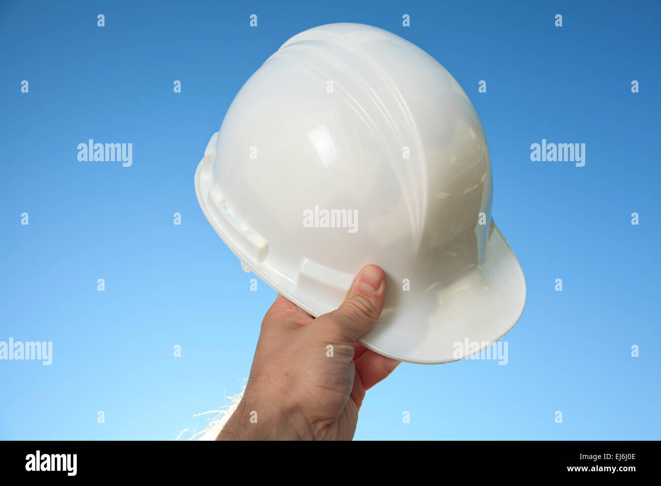 A hand holding a foreman helmet over the sky Stock Photo - Alamy