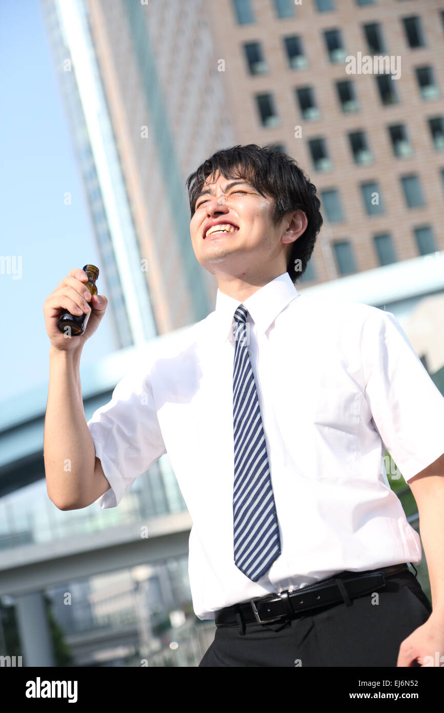 Japanese businessman drinking energy drink in the hot Japanese Summer ...