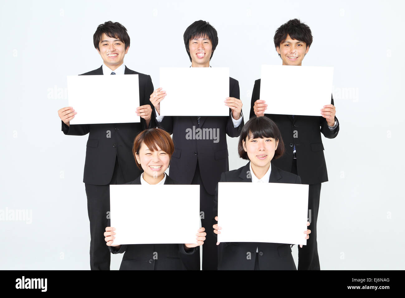 Young Japanese business people holding white boards Stock Photo - Alamy