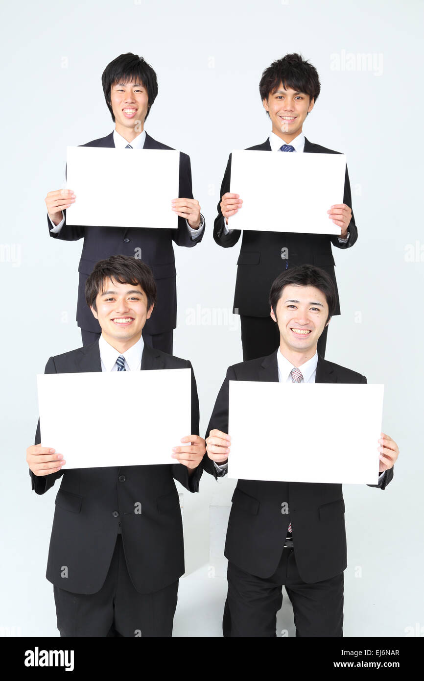 Young Japanese business people holding white boards Stock Photo - Alamy