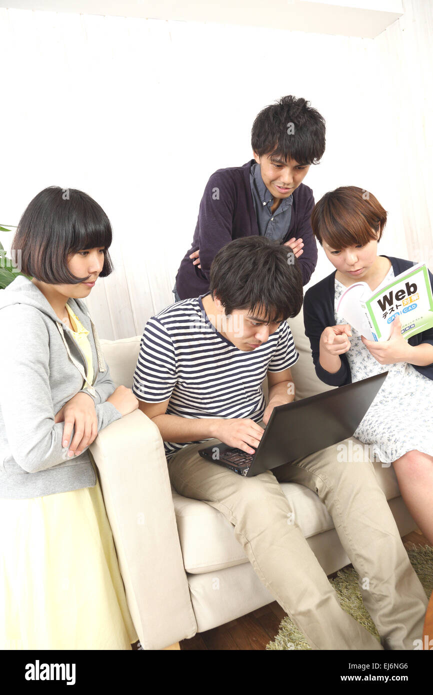Young Japanese people working with laptop on the sofa Stock Photo - Alamy