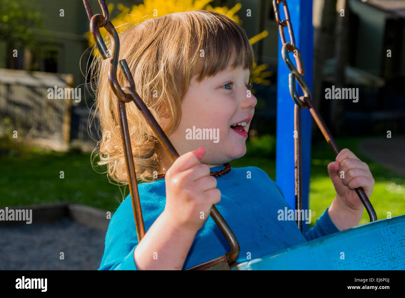 Happy boy on playground swing Stock Photo - Alamy