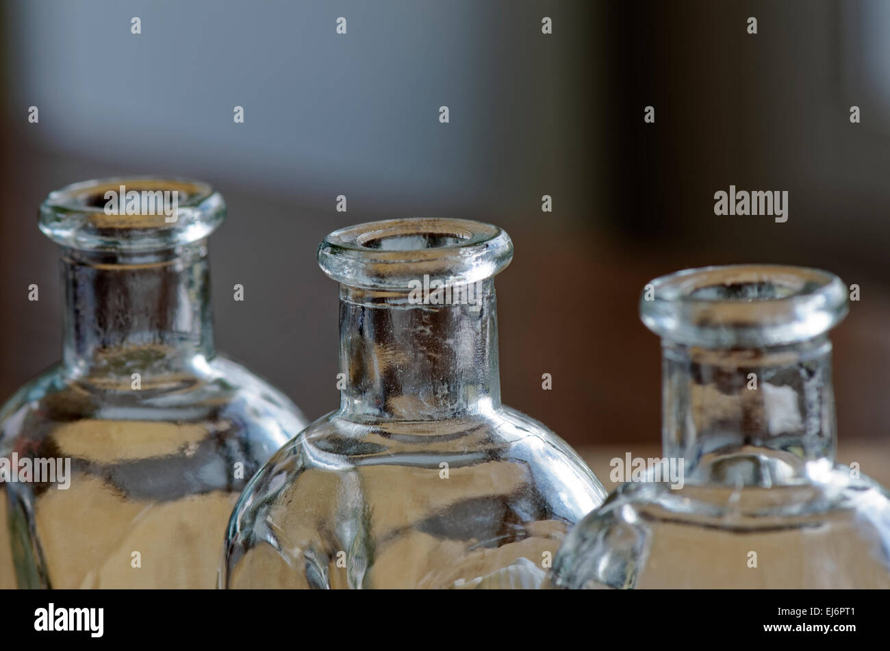 three empty clear glass bottles a row Stock Photo - Alamy