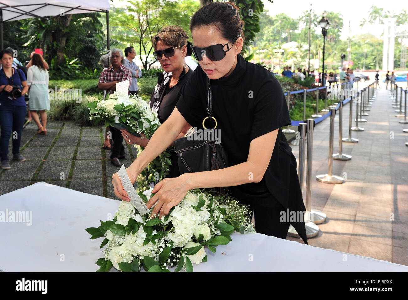 Singapore. 23rd Mar, 2015. A woman lays flowers and a condolence card ...