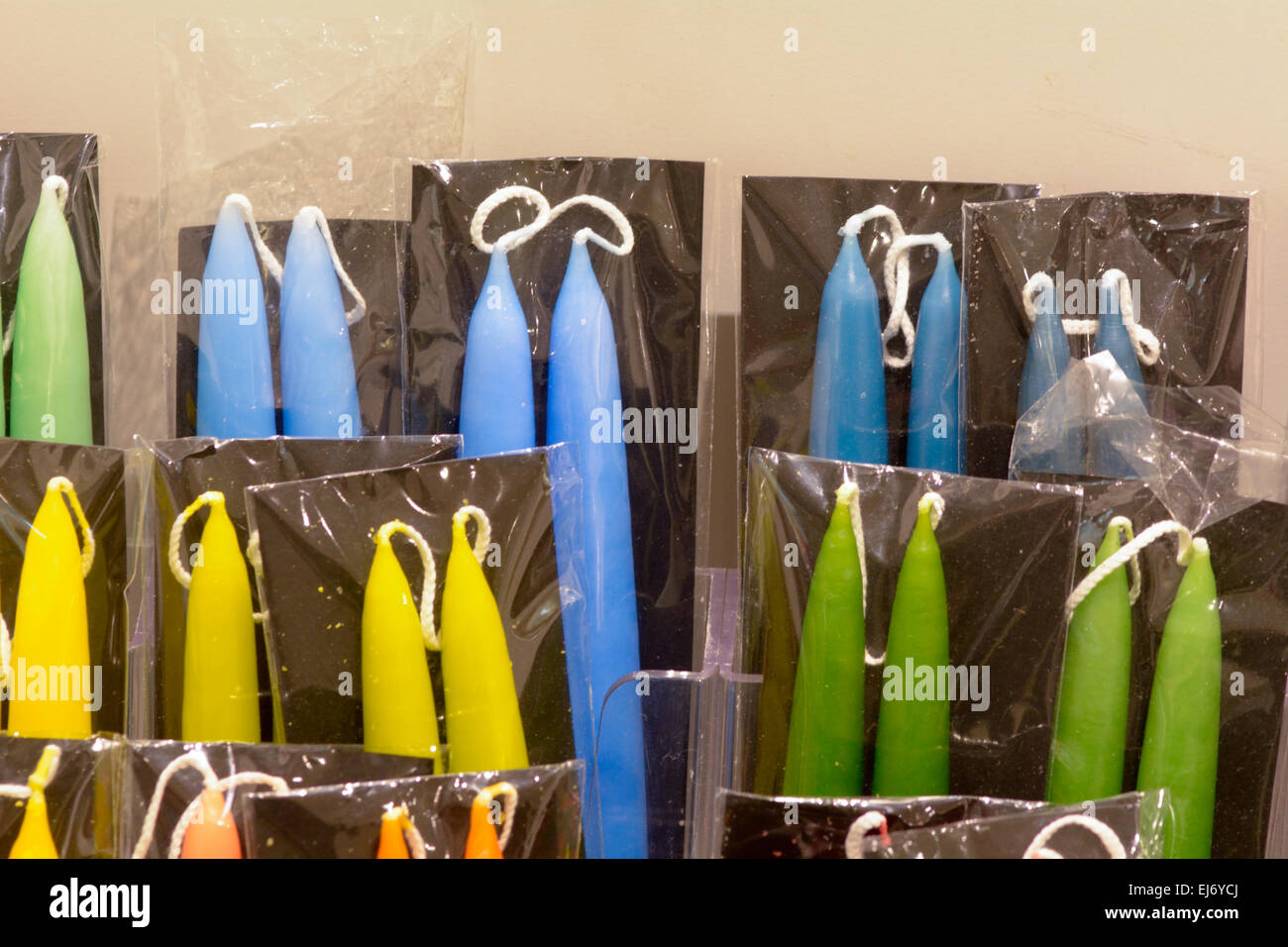 Pairs of color candles for sale in packets in shop Stock Photo - Alamy