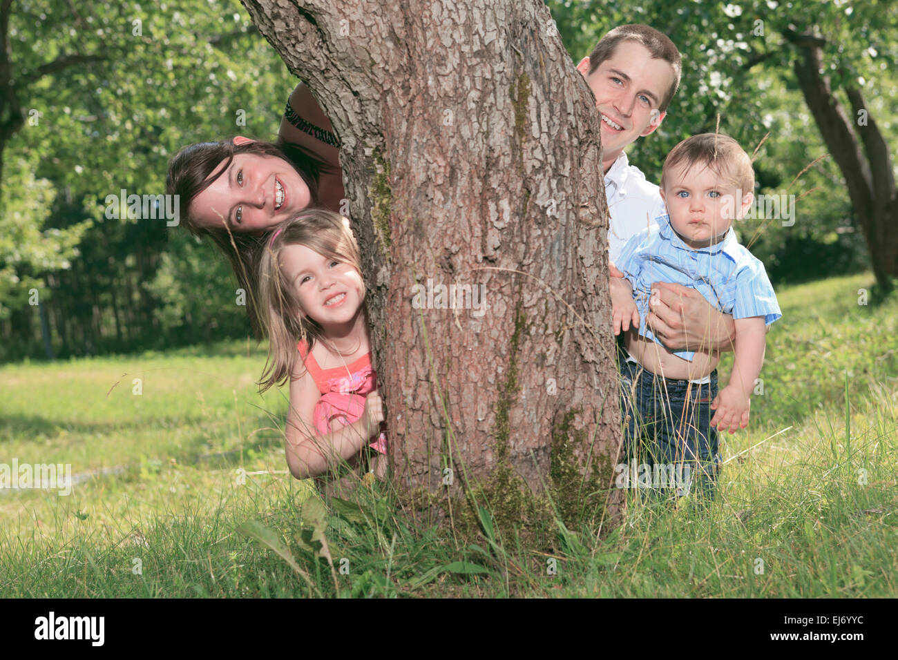 Boy girl hiding behind tree hi-res stock photography and images - Alamy