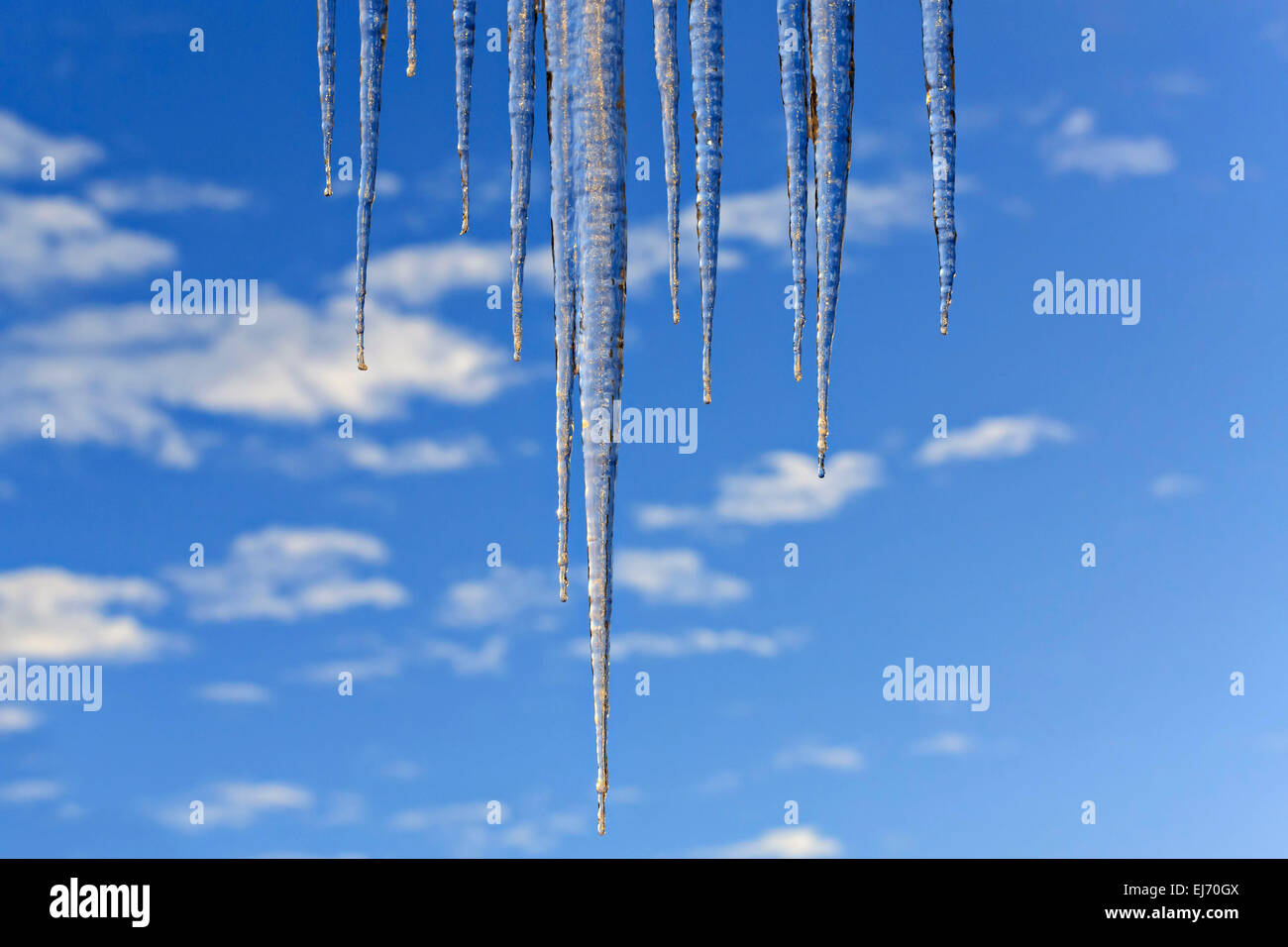 Frozen icicles against cloudy blue sky Stock Photo - Alamy