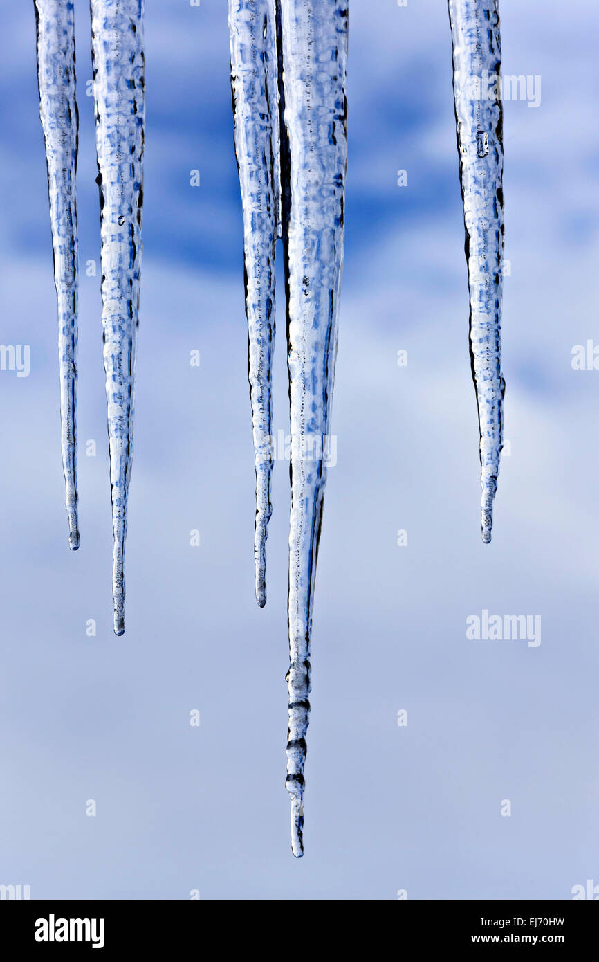 Frozen icicles against cloudy blue sky Stock Photo - Alamy