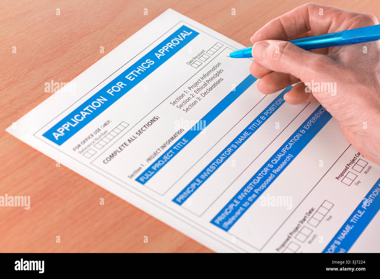 Hand with Pen Writing on Ethics Approval Application Stock Photo - Alamy
