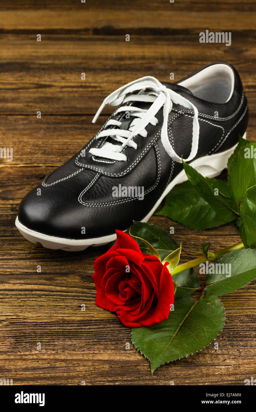 black man's shoe and rose on wooden background Stock Photo - Alamy