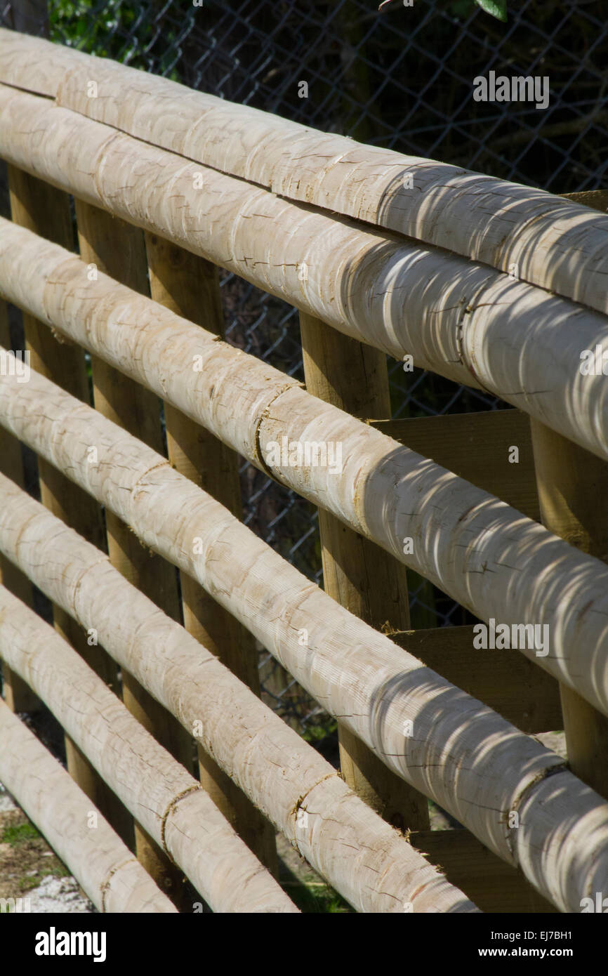 Fence / enclosure made from rounded wooden planks Stock Photo - Alamy
