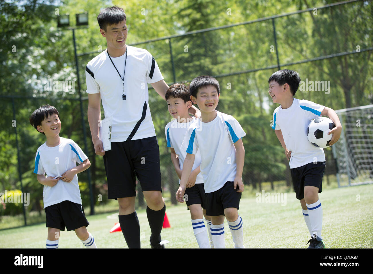 The football coach and the boys walking in the football field Stock ...