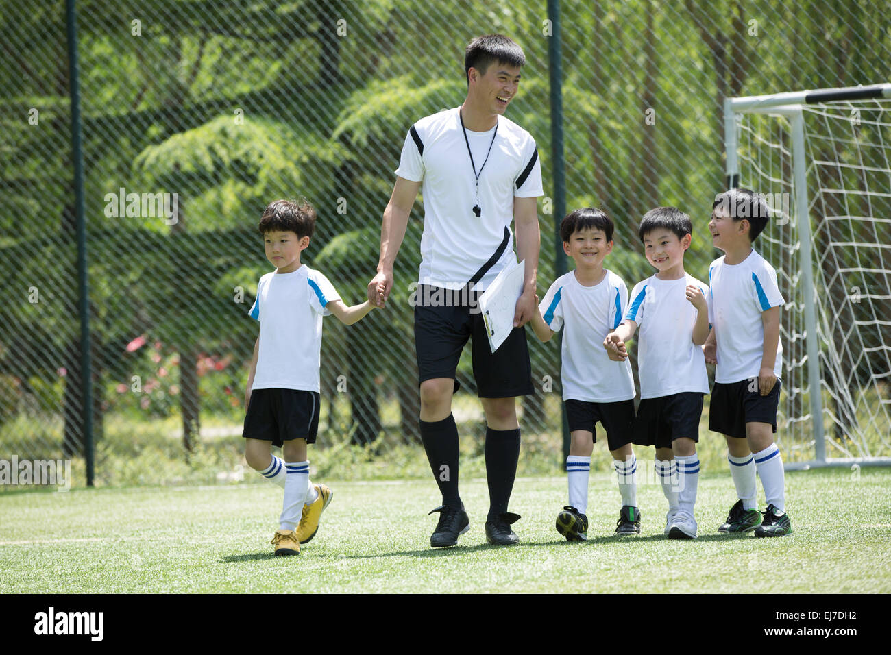The football coach and the boys walking in the football field Stock ...
