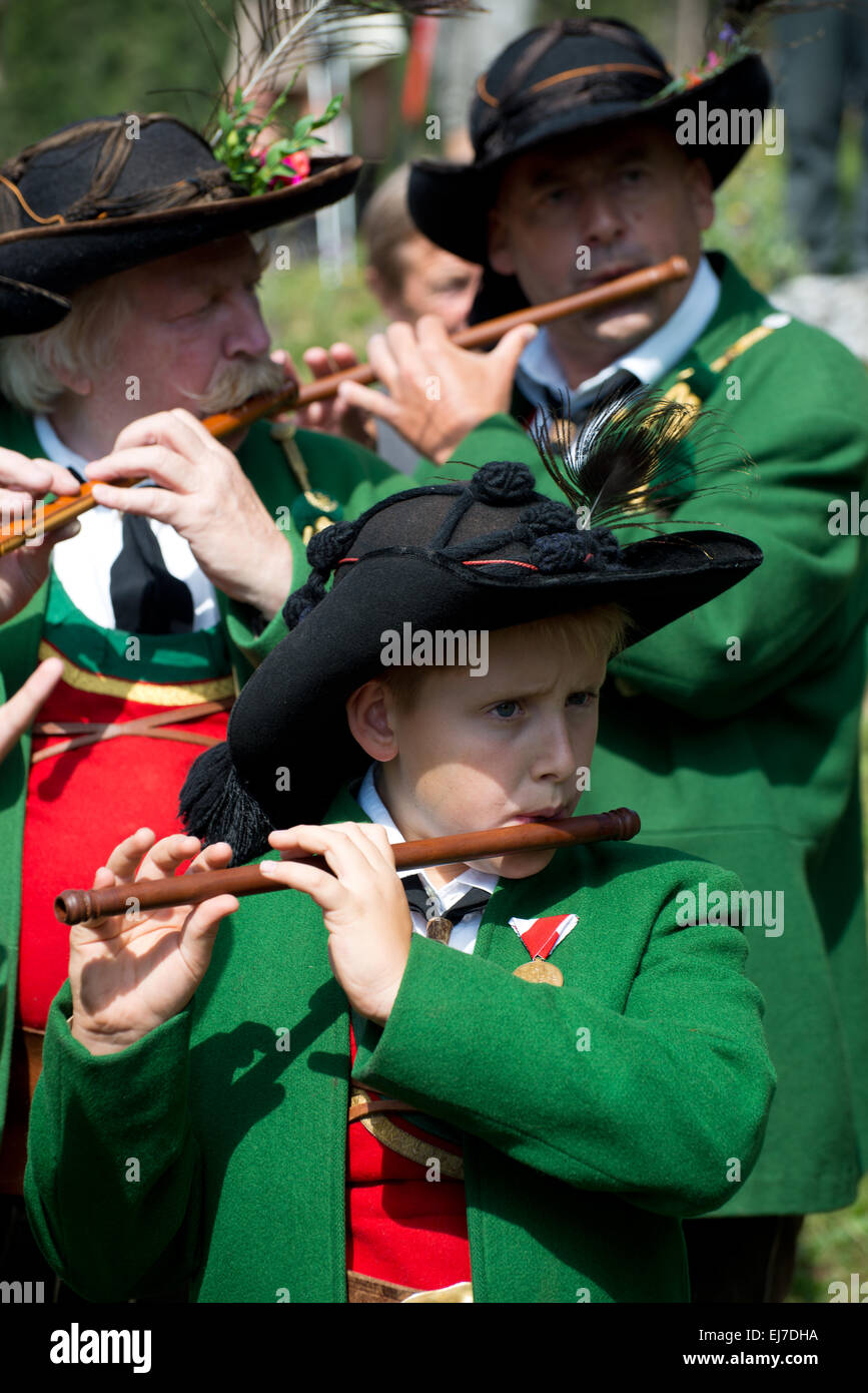 Boy and men in tyrolean costume playing cross flute hi-res stock ...