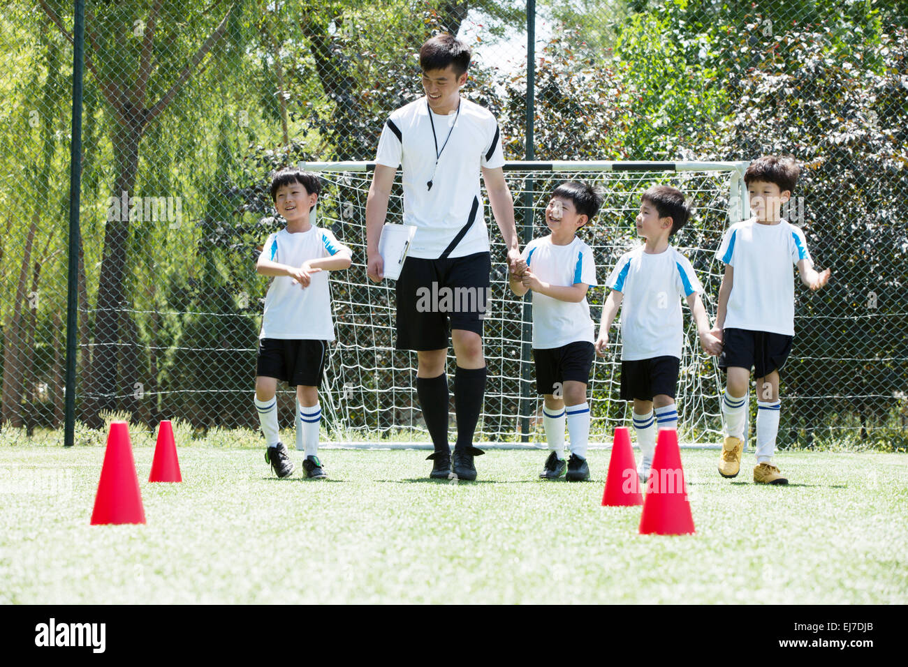 The football coach and the boys walking in the football field Stock ...