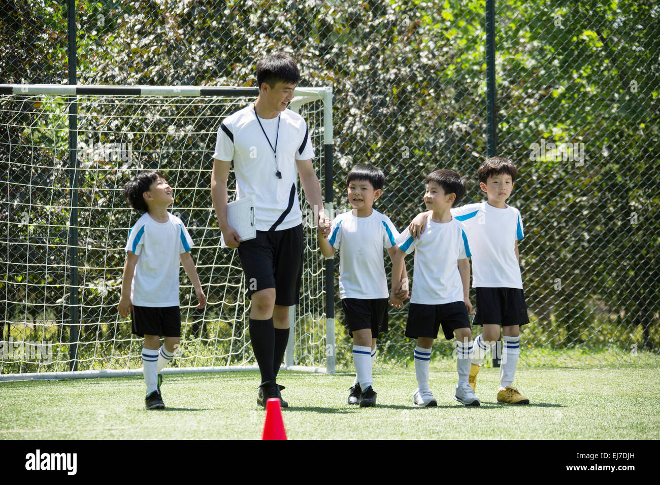 The football coach and the boys walking in the football field Stock ...