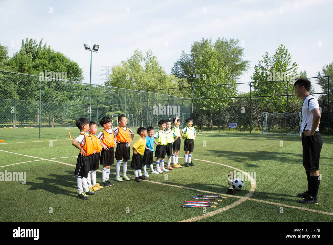 Football coach and the boys on the football field Stock Photo - Alamy