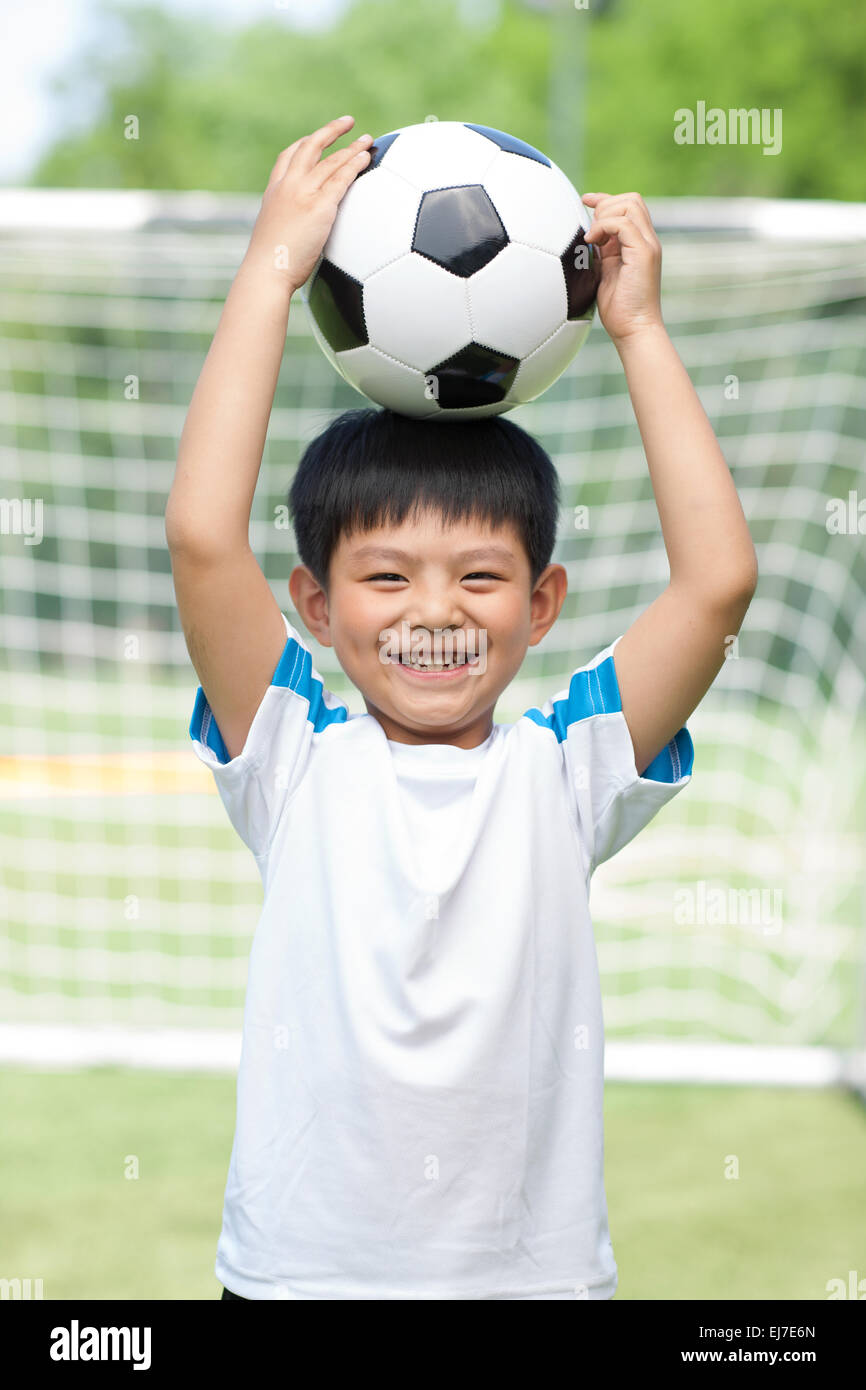 A boy put football on the head Stock Photo - Alamy