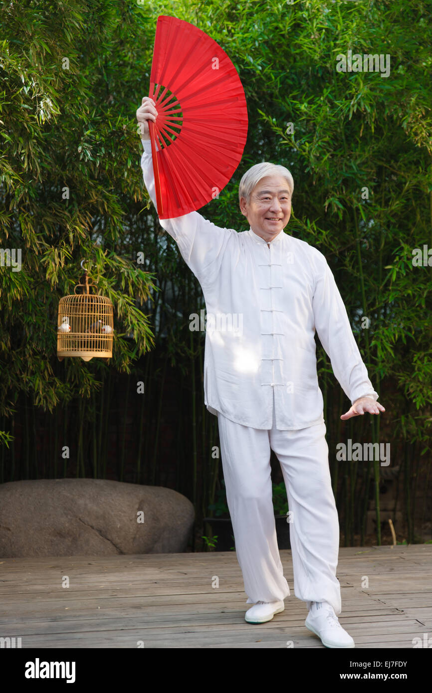 An old man holding a fan in the morning exercise Stock Photo - Alamy