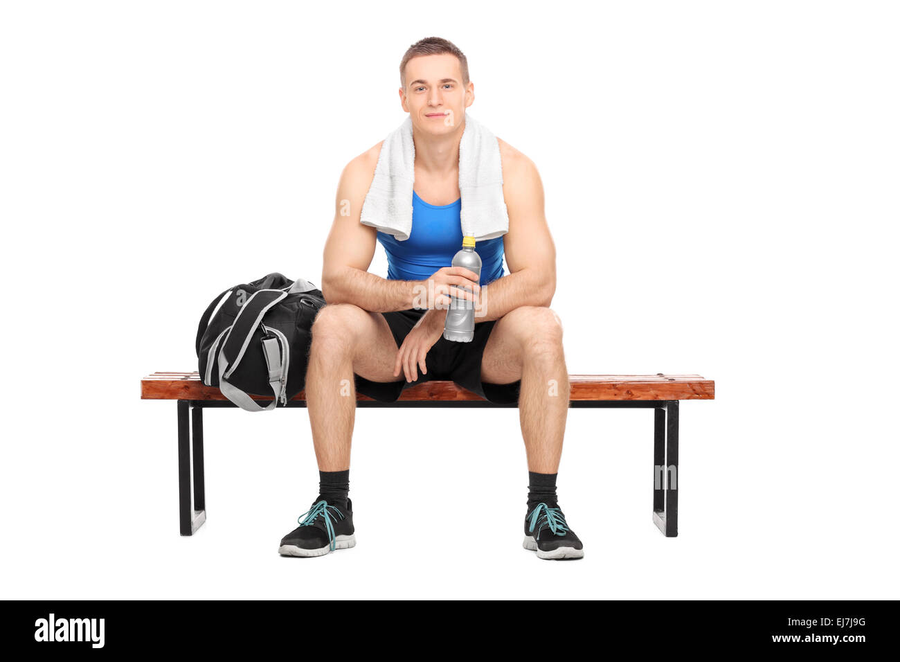 Young muscular athlete sitting on a wooden bench Stock Photo - Alamy