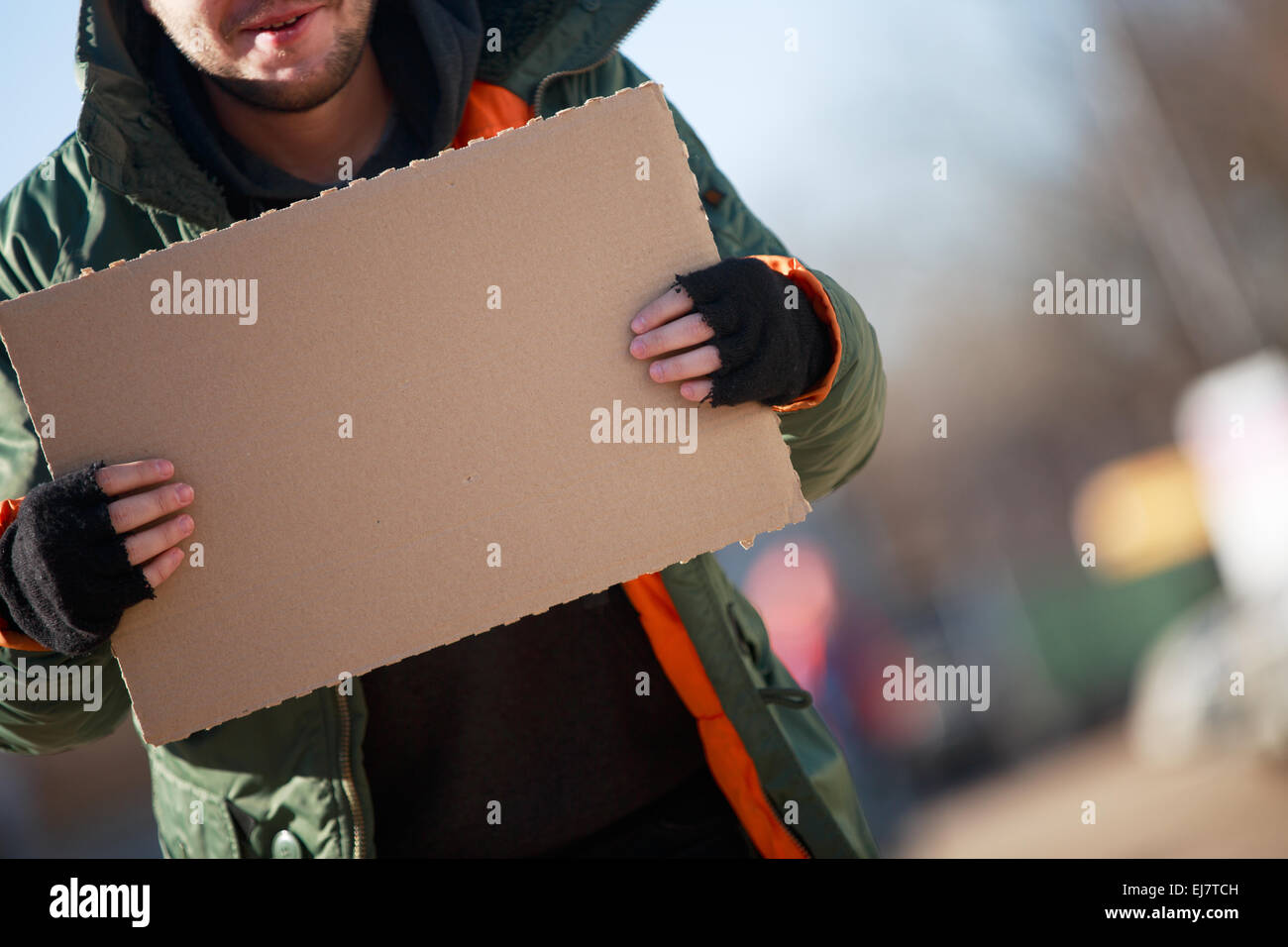 Homeless person with blanck cardboard Stock Photo - Alamy