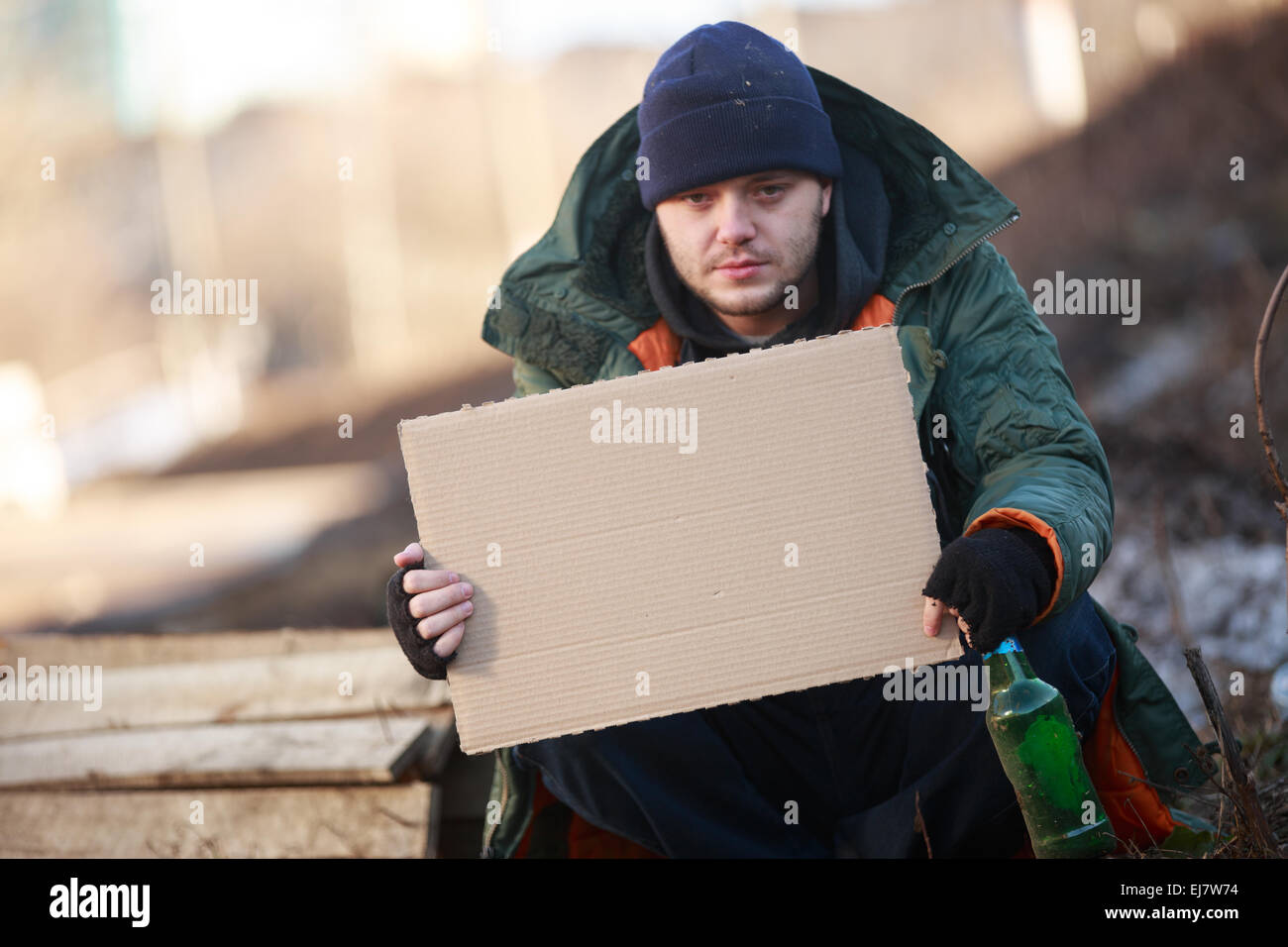 Homeless man holds blank cardboard for your text Stock Photo - Alamy