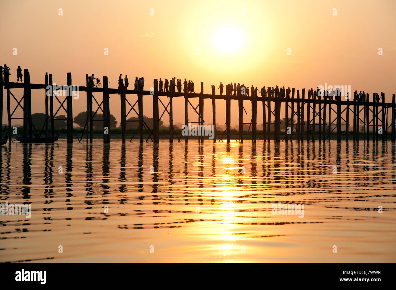 Sunset silhouettes of people walking over the U Bein teak bridge in ...