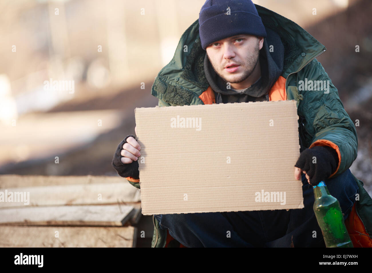 Homeless man holds blank cardboard for your text Stock Photo - Alamy