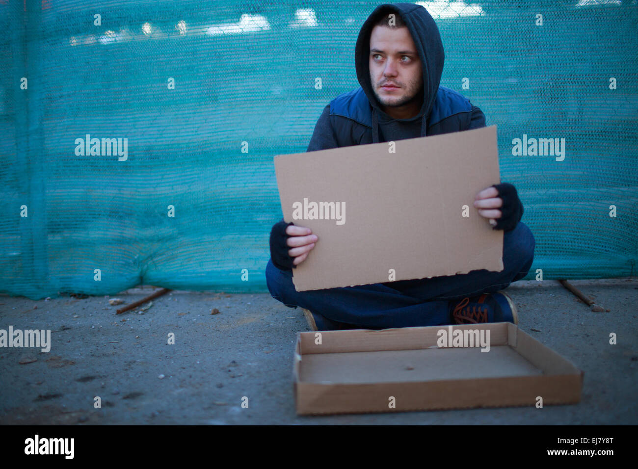 Homeless man holds blank cardboard for your text Stock Photo - Alamy