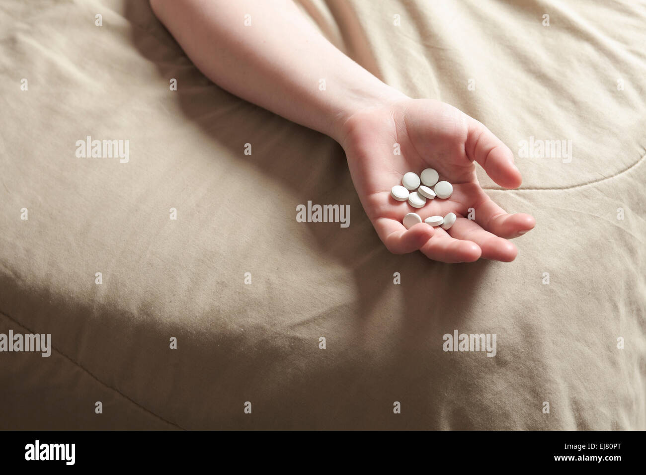 A sad woman taking medication on bed Stock Photo - Alamy