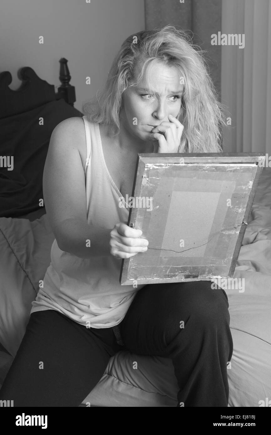 A sad woman take a look on picture frame Stock Photo - Alamy