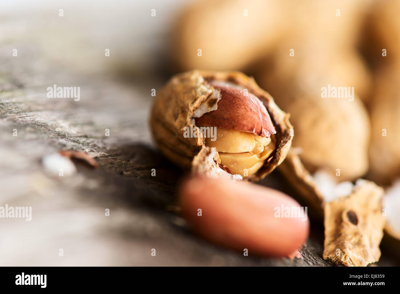Peanuts in shell on wooden table crashed close up Stock Photo - Alamy