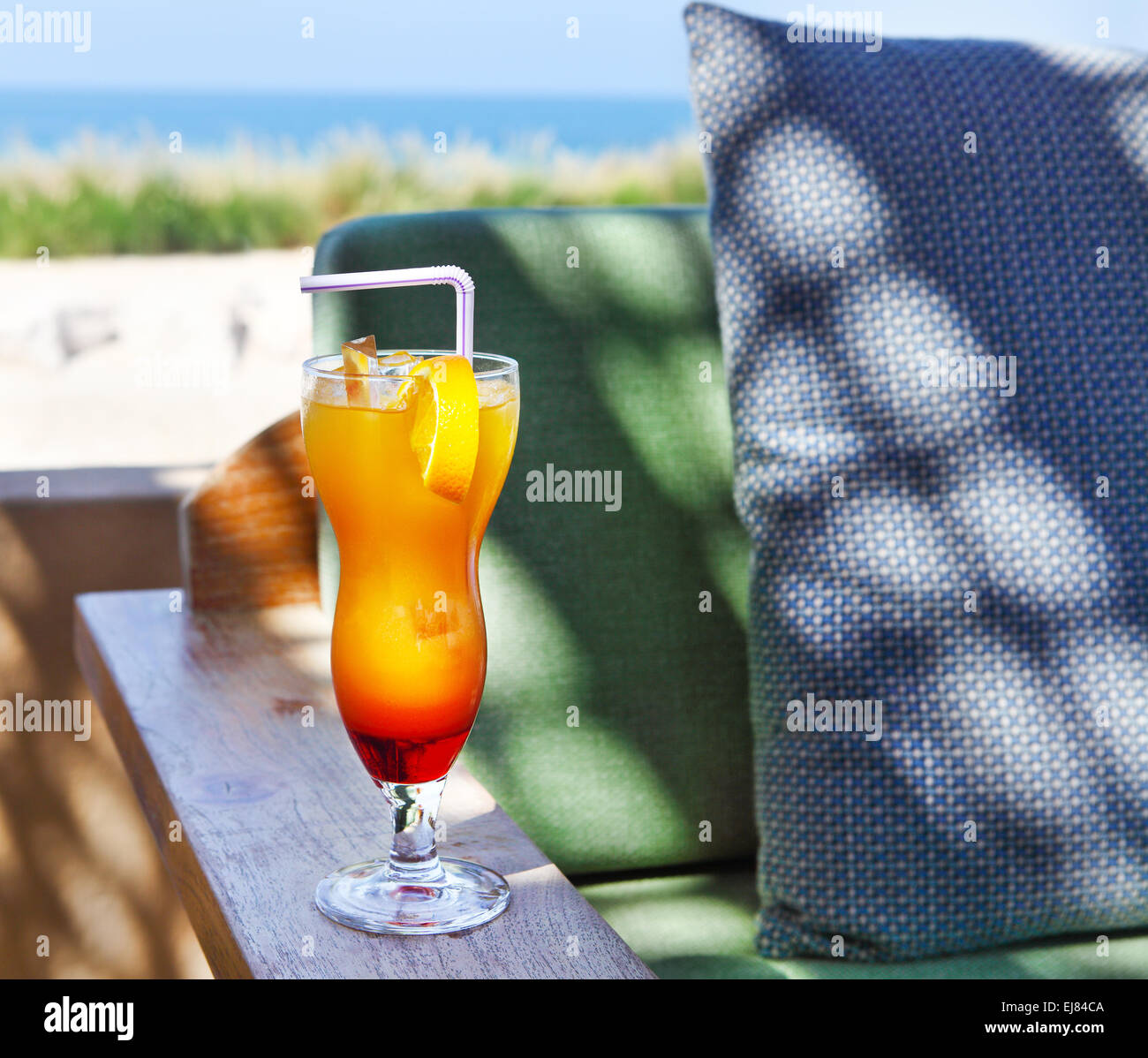 Orange cocktail on beach table Stock Photo - Alamy