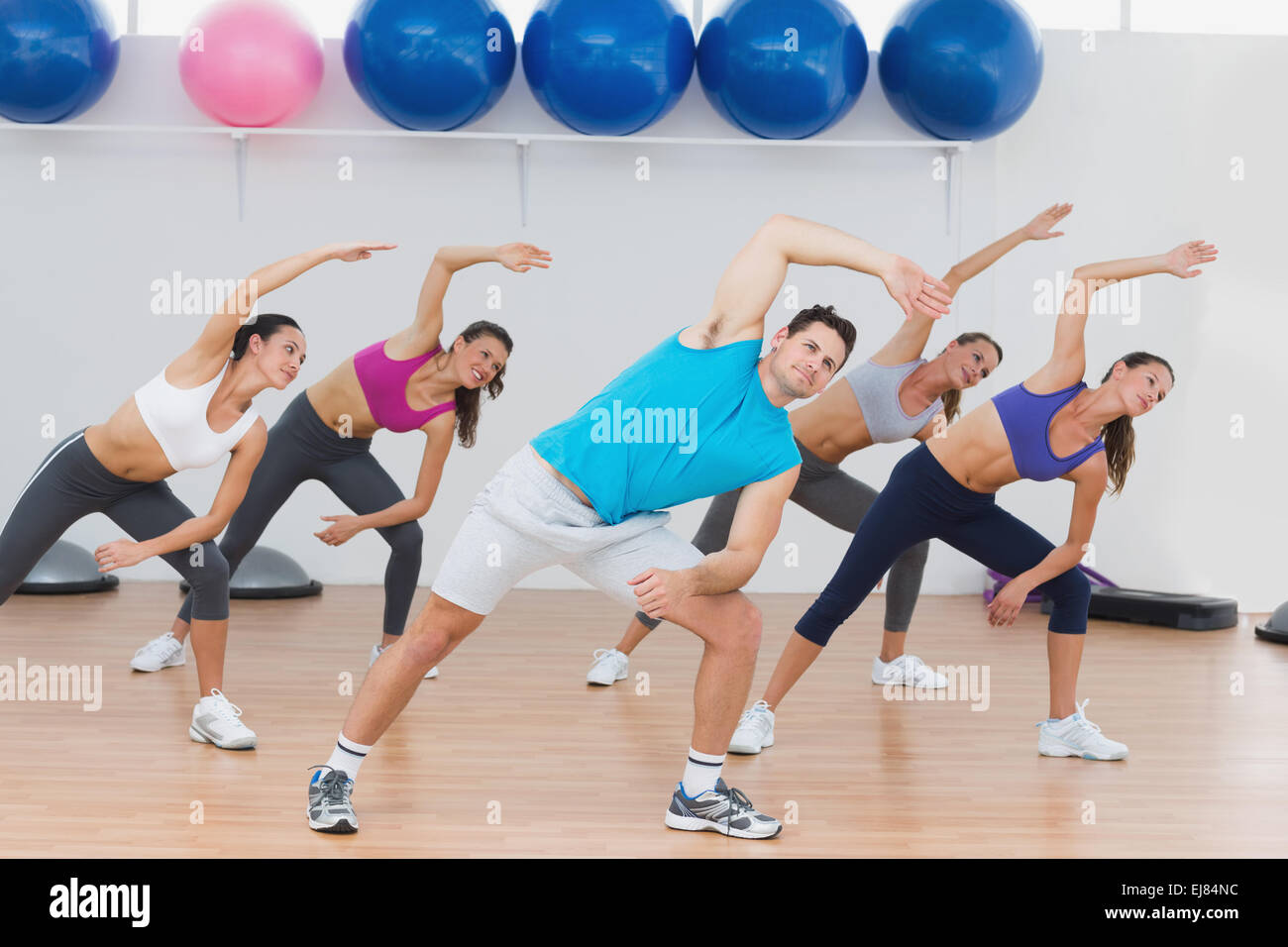 Class doing stretching exercise in fitness studio Stock Photo - Alamy