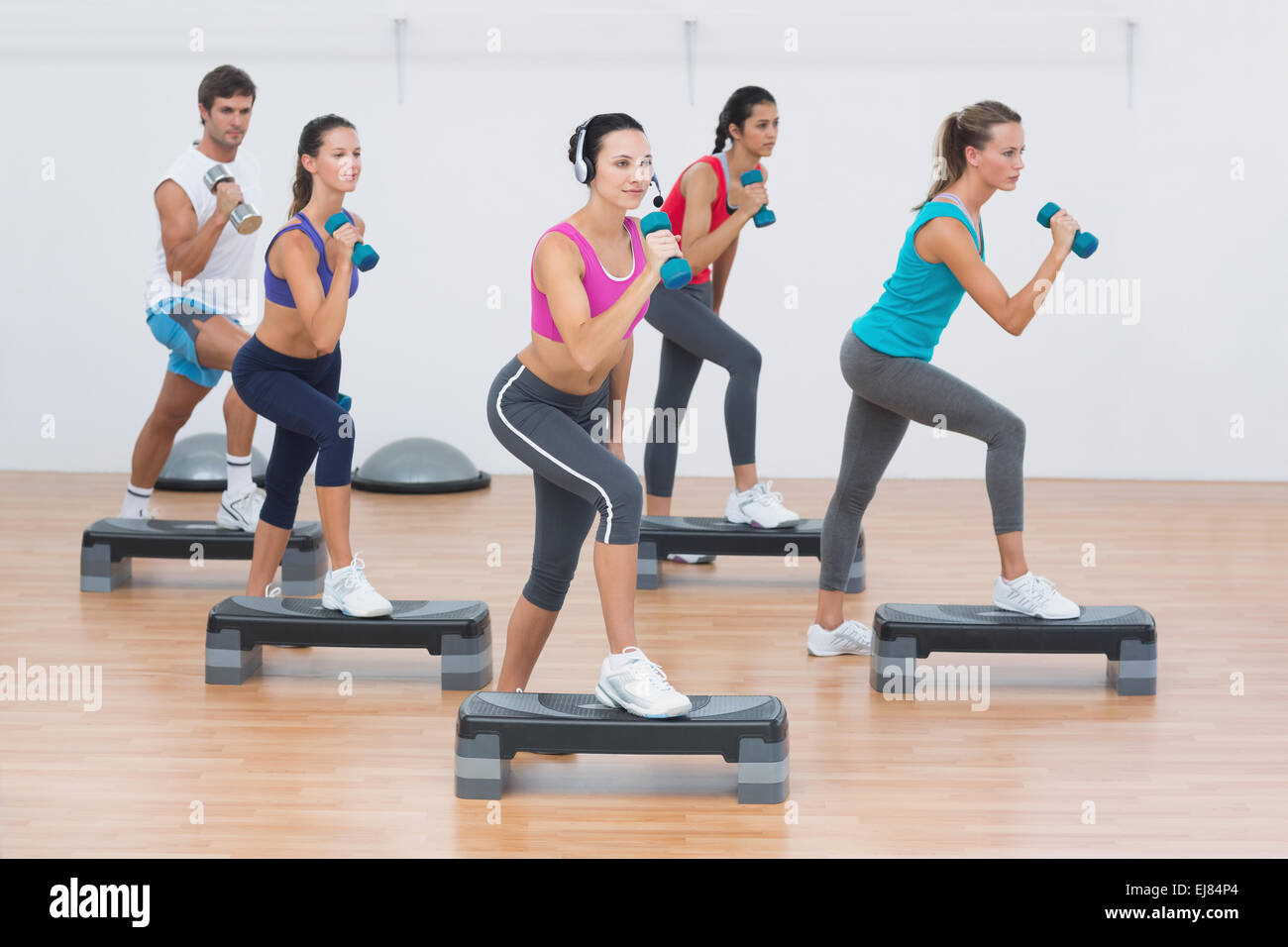 Fitness class performing step aerobics exercise with dumbbells Stock ...