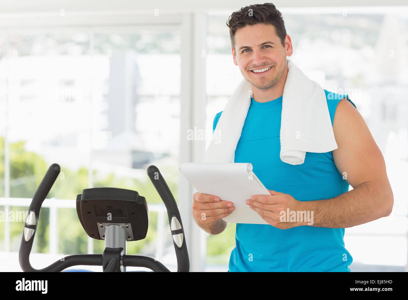 Smiling trainer with clipboard in gym Stock Photo - Alamy
